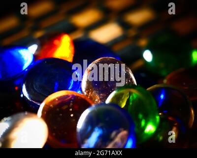 Closeup of fun vibrant glass gems reflecting bright lights on a ...