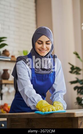 Young pretty Muslim woman with glass of coffee resting in chair and ...