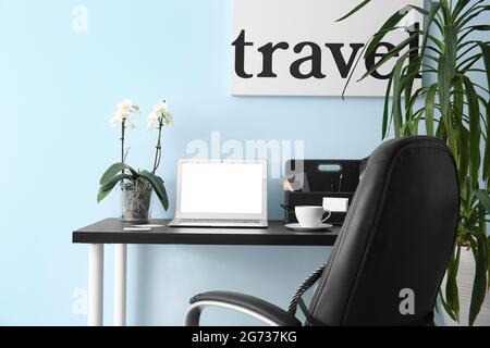 Comfortable workplace with modern laptop and orchid flower near color ...