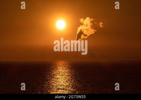 Sunset and Steam. The sunsets as steam rises from the chimney of a ...