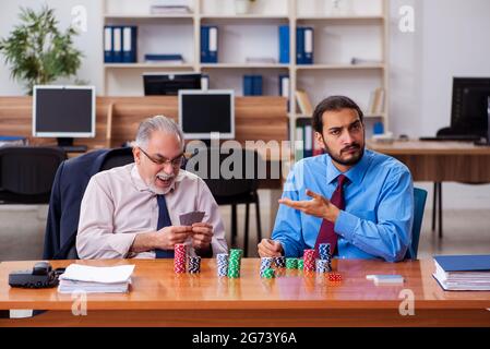 Two employees playing cards at workplace Stock Photo - Alamy