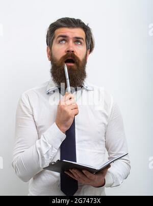 Handsome surprised man with pen and notebook in hands, isolated on ...