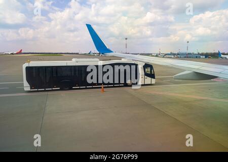 Passengers boarding a shuttle bus from Pegasus airplane to airport on ...