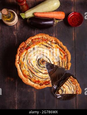 The cut piece of Vegetable Spiral tart with zucchini, eggplant, carrot ...