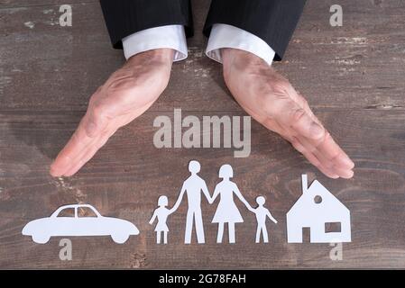Family, house and car covered by hands - insurance concept; panoramic ...