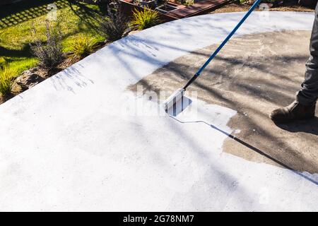 painting backyard or driveway concrete paving with paint roller concept of DIY and home improvement Stock Photo Alamy