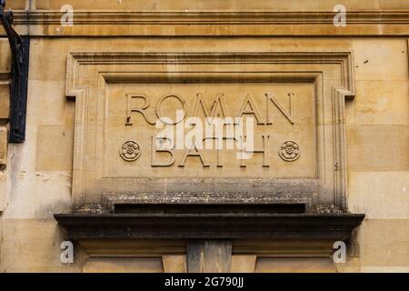 Stone carved sign at the Roman Baths with the Bath Abbey in the ...