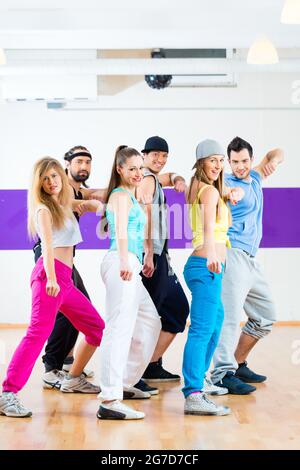 Group of men and women dancing zumba fitness choreography in dance ...