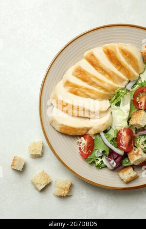 Plate of tasty Caesar salad and ingredients on color background Stock ...