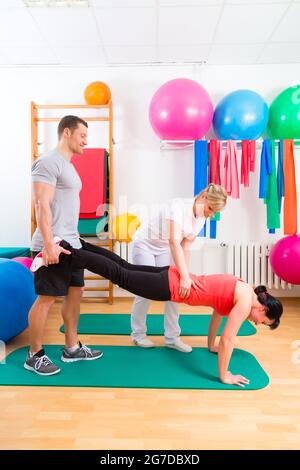 Patients at the physiotherapy doing physical exercises with therapist ...