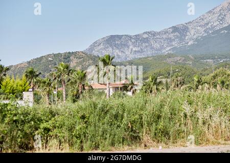 Street view in Kemer: mountains, green beautiful nature, homes on sunny ...