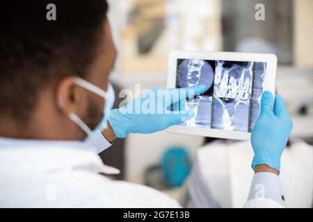 Doctor checking the xray on his tablet pc in hospital room for her ...