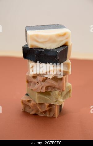 Vertical shot of stacked handmade bars of hand soap on a beige surface ...