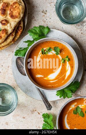 Creamy coconut and ginger soup in a saucepan and fried crustaceans in a ...