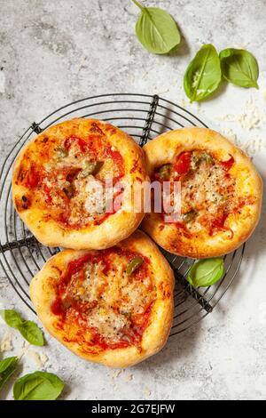 Mini pizzas - pizzette - topped with cheese and tomato plus Italian ham ...