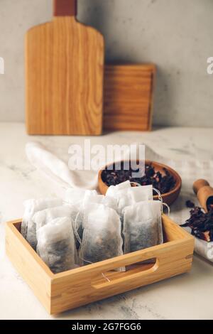 Bag, bowl and scoop with dry tea leaves on dark background Stock Photo ...