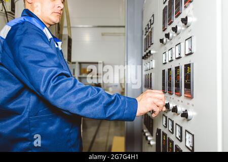 A worker presses a button and starts an automatic manufacturing process ...