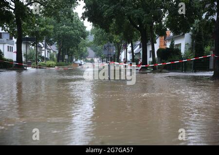 Erkrath, Germany. 14th July, 2021. Firefighters set up a water barrier ...