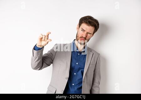 Businessman trying to see something small, showing little thing size ...