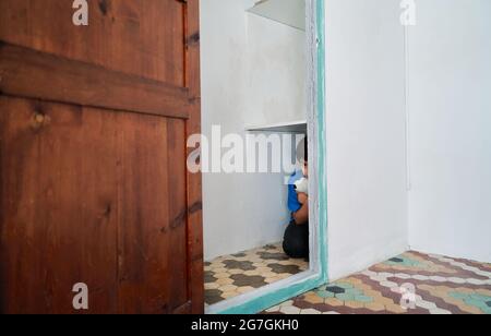 Scared little boy suffering from sciophobia and phantom behind him ...