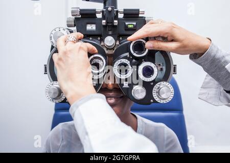Optometrist adjusting the optometry equipment during study of the ...