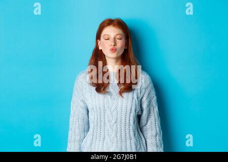 Cute redhead teen girl waiting for kiss, pucker lips and close eyes ...