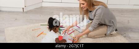 happy mother drawing with adopted african american girl while sitting ...