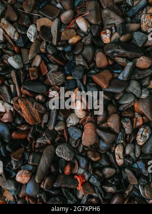A closeup shot of small rocks on the beach and in the water Stock Photo ...