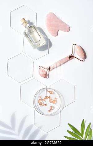 Pink quarts face roller, gua sha stone, pink cream in glass jar. Off ...