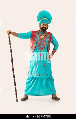 A Bhangra dancer holding a Khunda in his hand Stock Photo - Alamy