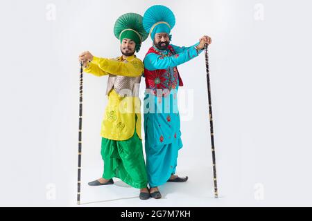 Two Bhangra Dancers standing with Khunda Stock Photo - Alamy