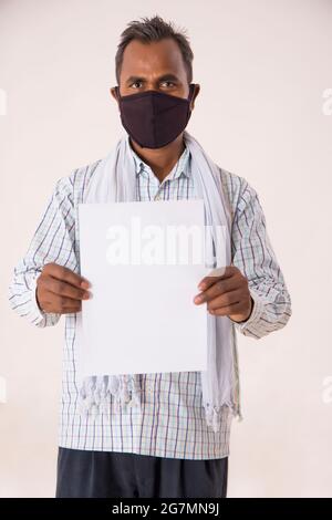 A MANUAL LABOURER WEARING FACE MASK LIFTING LARGE BLOCK OF TILE Stock ...
