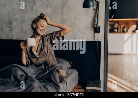 Photo portrait of woman in pajama sleeping mask blowing air balloon ...
