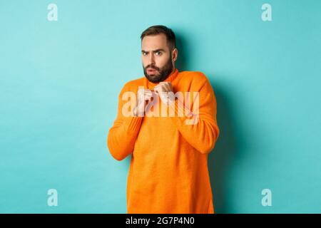 Scared guy jumping startled, looking at something scary, standing in ...