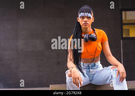 Young native American trap dancer with braids wearing an orange shirt ...