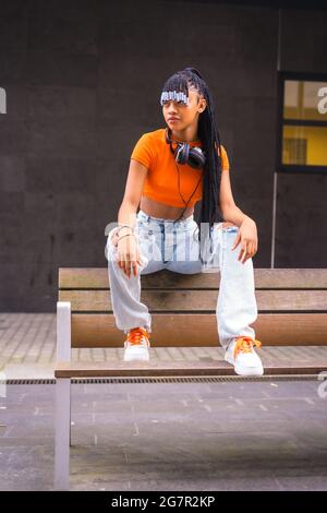 Young native American trap dancer with braids wearing an orange shirt ...
