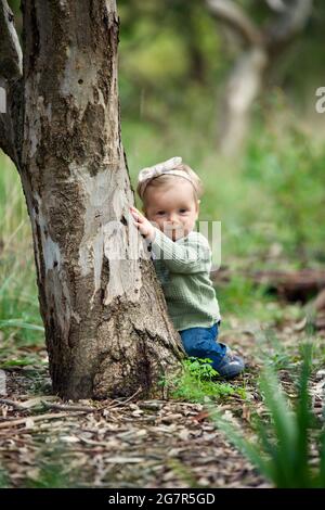 Australian kid hiding behind a tree Stock Photo - Alamy