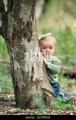 Australian kid hiding behind a tree Stock Photo - Alamy