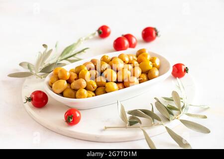 Scratched yellow olives. Tasty organic yellow olives in the plate ...