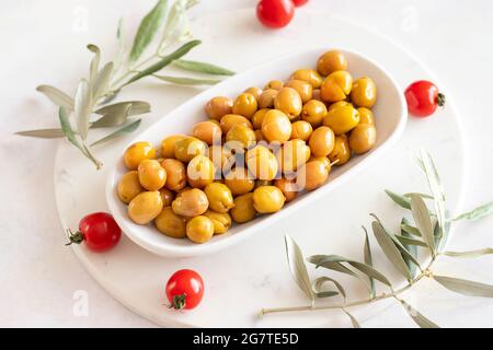 Scratched yellow olives. Tasty organic yellow olives in the plate ...