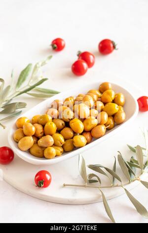 Scratched yellow olives. Tasty organic yellow olives in the plate ...