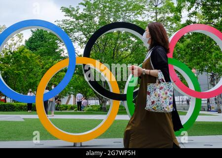 A woman walks past a Tokyo Olympic and Paralympic Games countdown clock ...