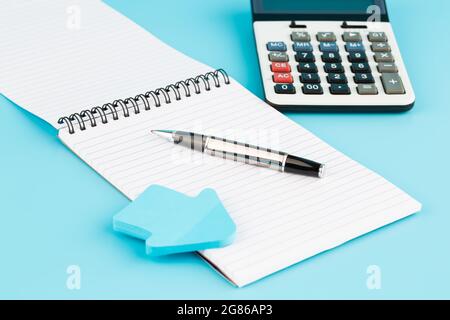 Calculator, blue pen and notepad on blue background Stock Photo - Alamy