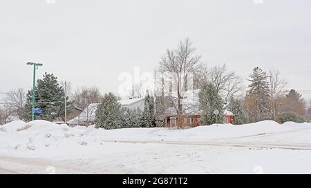 Typical canadian houses with big heaps of snow in front on a cold grey ...