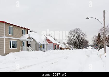 Typical canadian houses with big heaps of snow in front on a cold grey ...