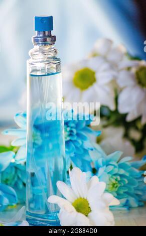 Bottle of perfume with floral fragrance on blue background Stock Photo ...