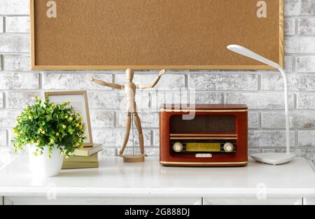 Retro radio receiver with mannequin on table near brick wall Stock ...