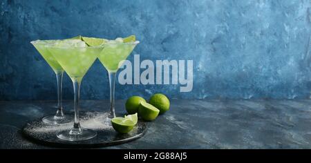 Slate plate with glasses of tasty daiquiri cocktail on color background ...