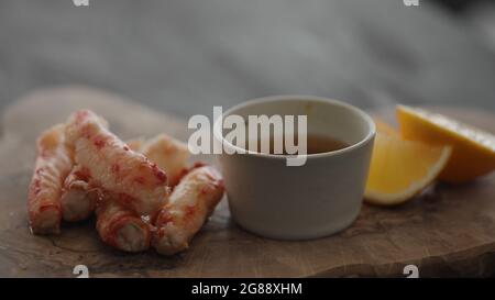 Slow motion gimbal shot of crab leg meat on a olive board with sweet ...