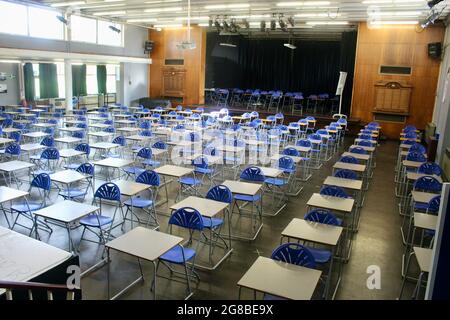 english school hall full of lines of chairs and tables for examinations ...